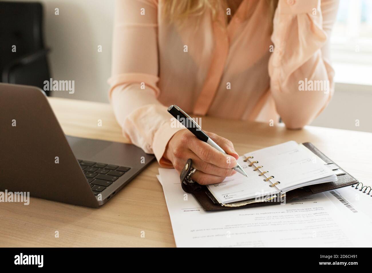 Woman making notes in diary Stock Photo - Alamy