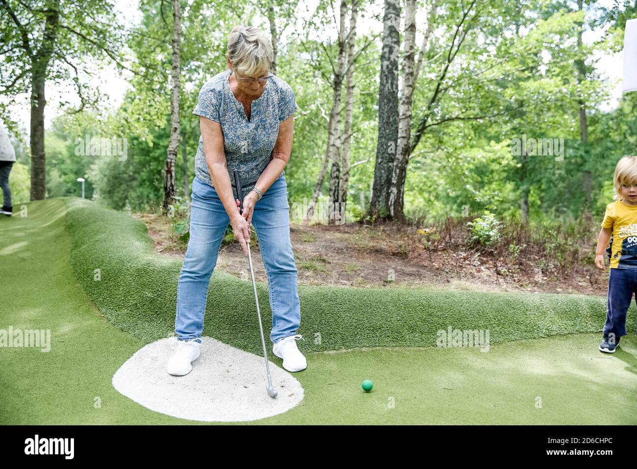 Woman playing mini golf Stock Photo - Alamy