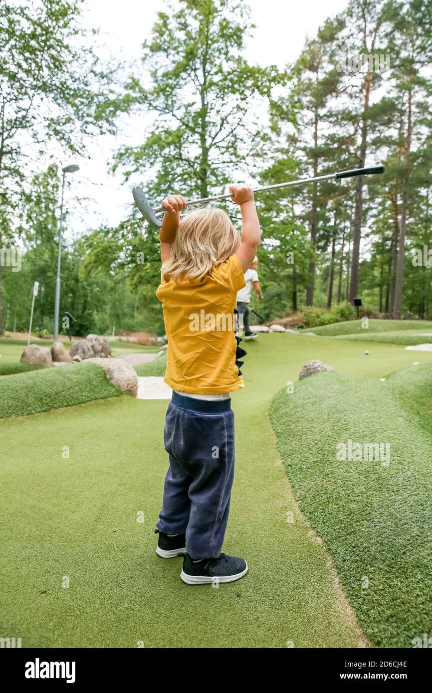 Boy playing mini golf Stock Photo - Alamy