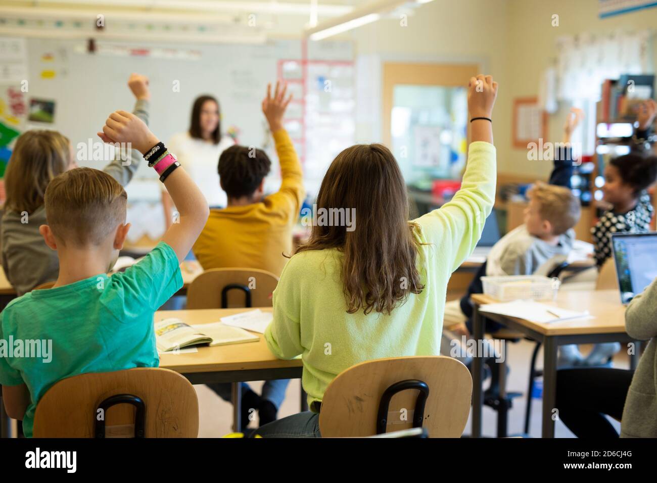 Children raising hands in classroom Stock Photo - Alamy
