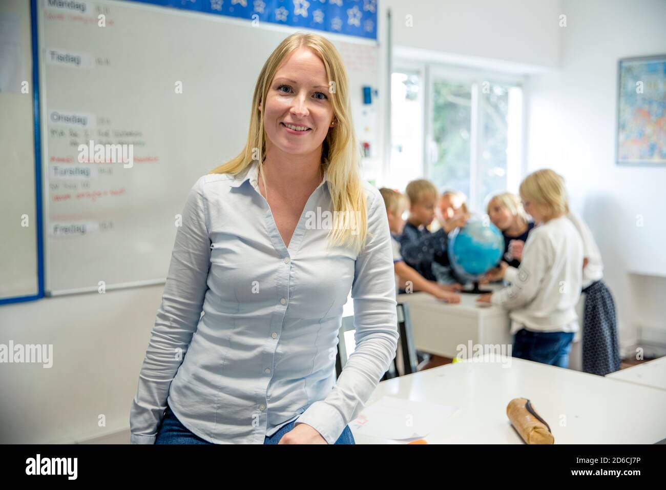 Teacher standing in classroom Stock Photo - Alamy