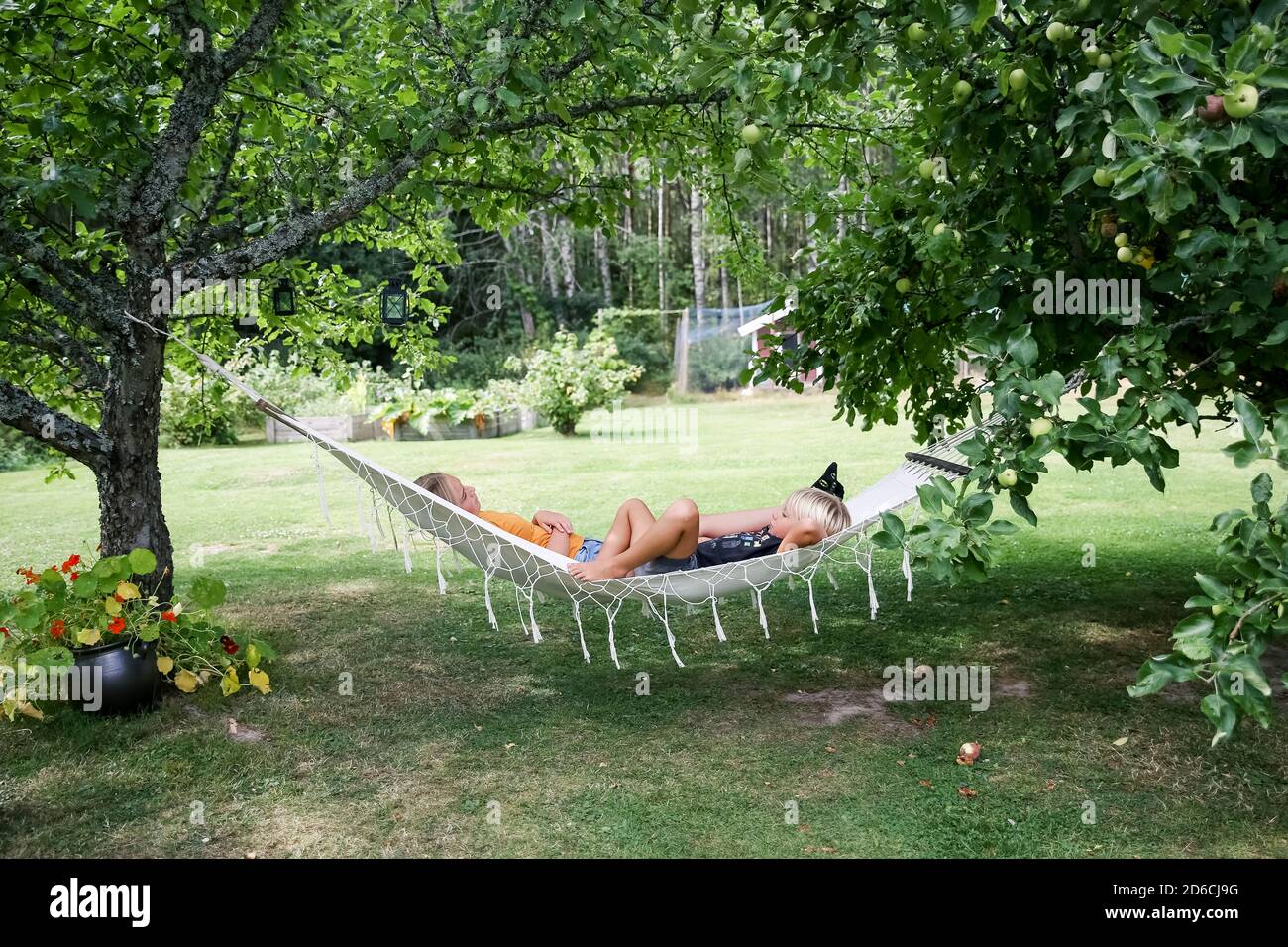 Kids relaxing on hammock Stock Photo - Alamy