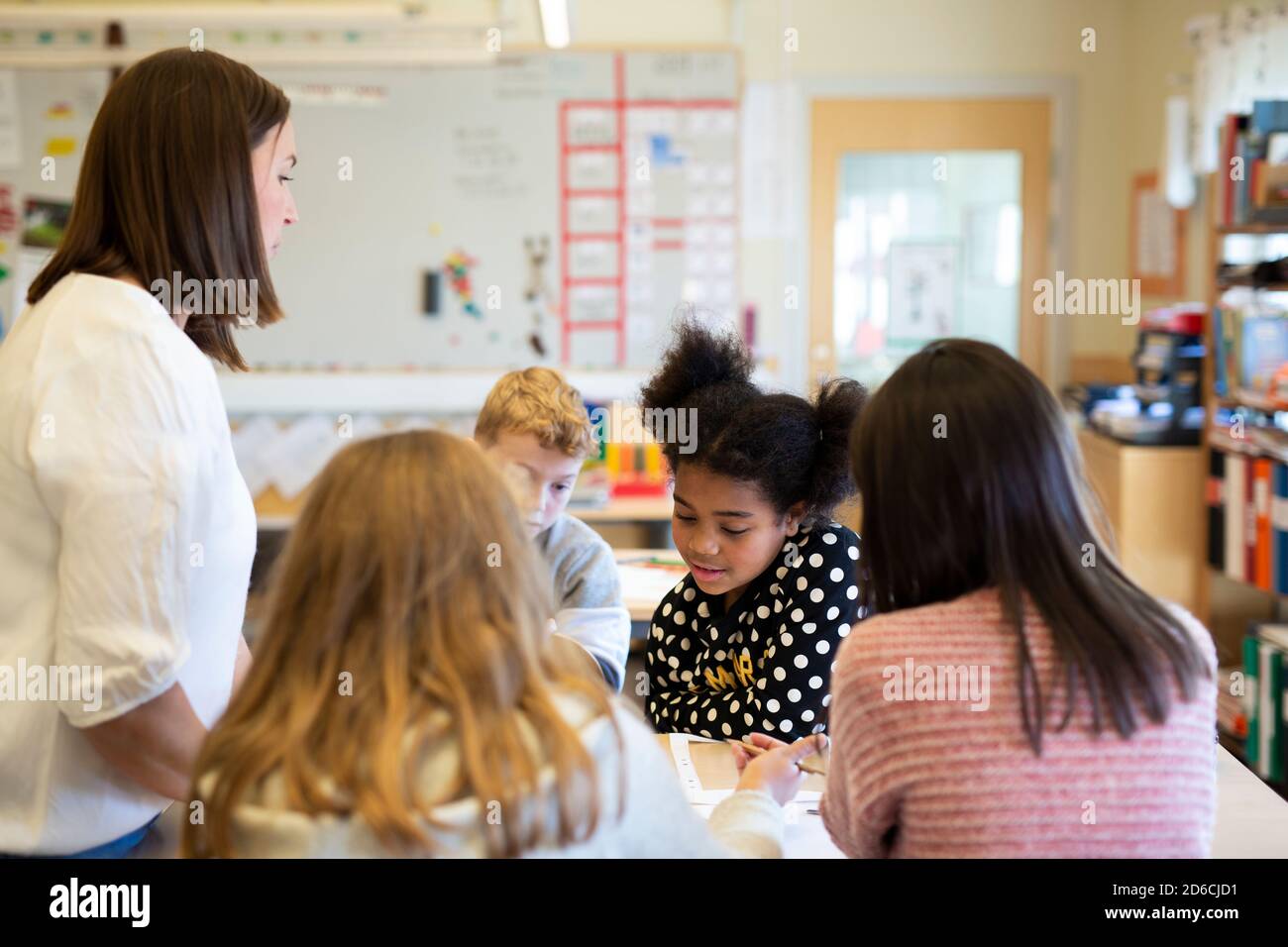 Teacher with children in classroom Stock Photo - Alamy
