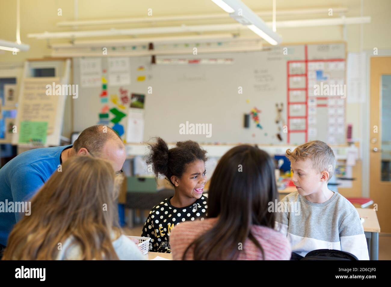 Teacher with children in classroom Stock Photo - Alamy