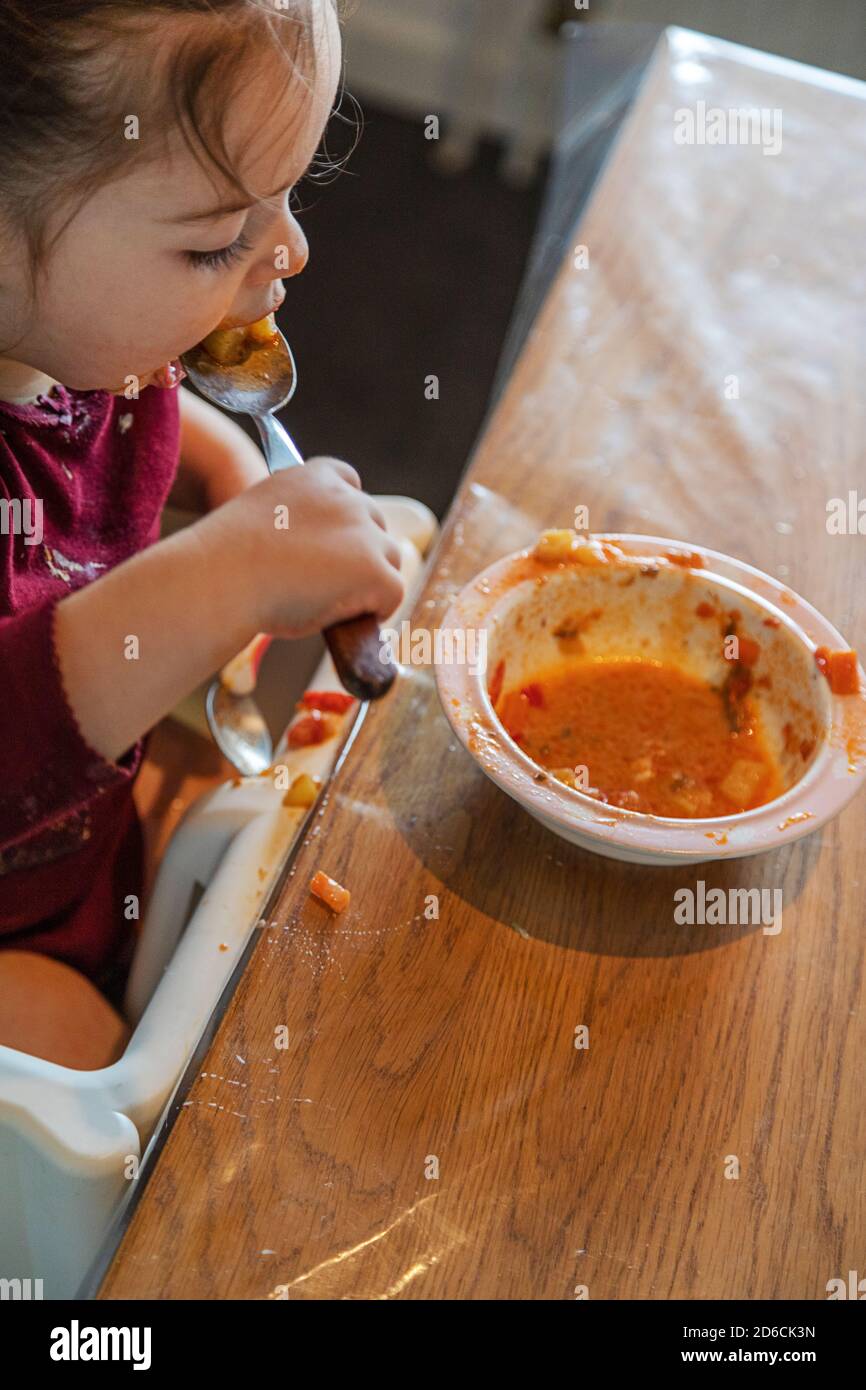 Girl eating at table Stock Photo - Alamy