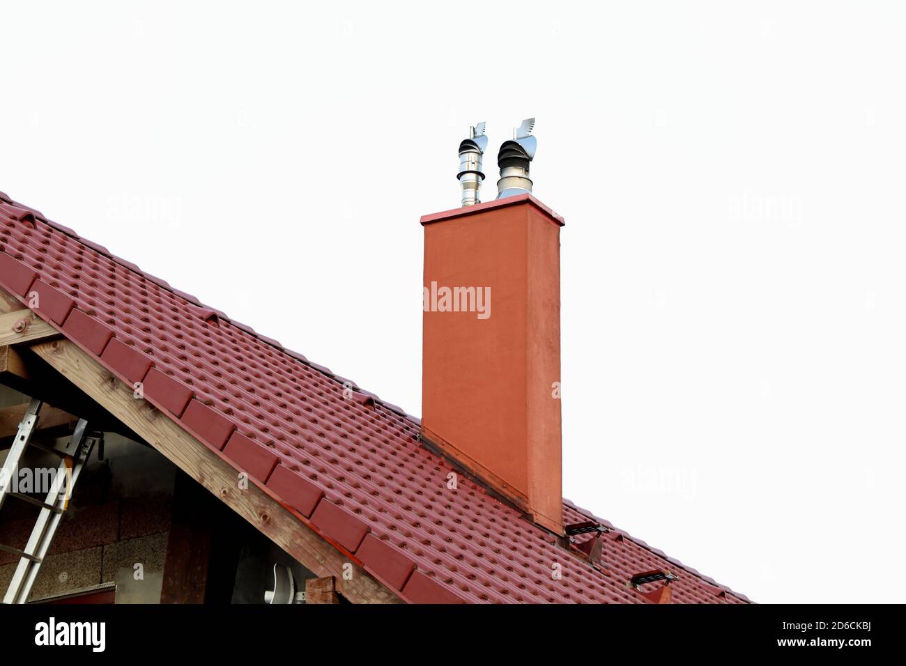 Detail of a chimney on a red classic saddle tile roof separated on a ...