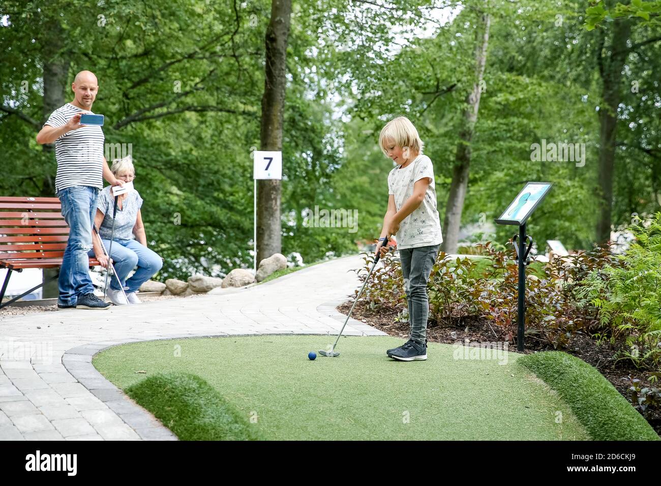 Boy playing mini golf Stock Photo - Alamy