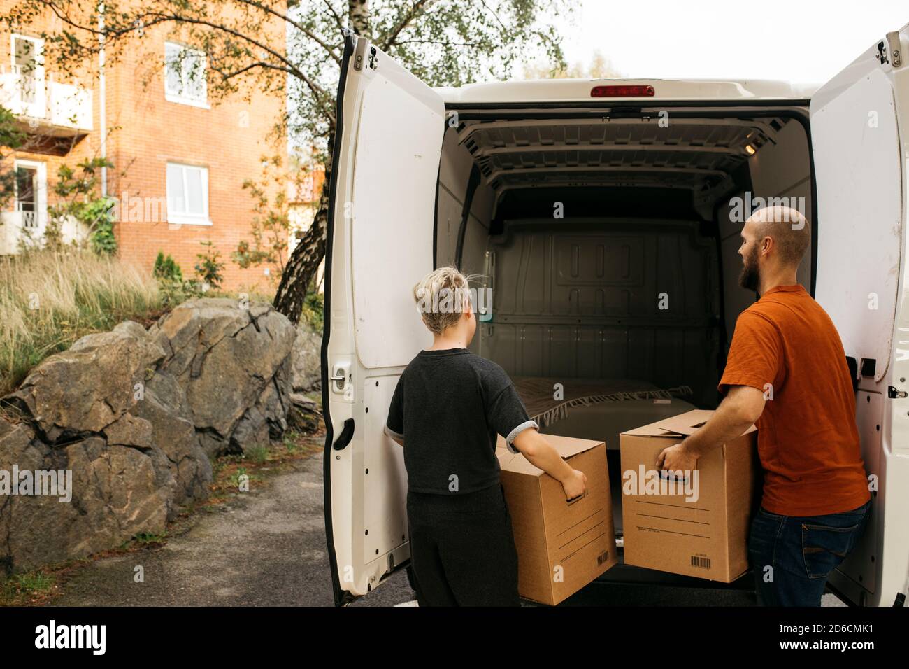 Couple putting boxes into van Stock Photo - Alamy