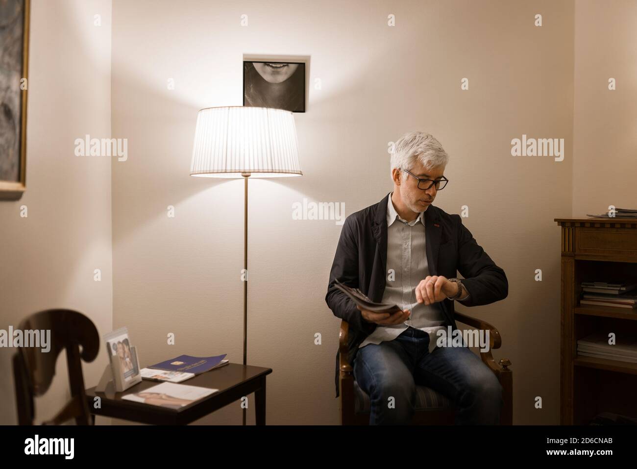 Man in waiting room checking time Stock Photo - Alamy