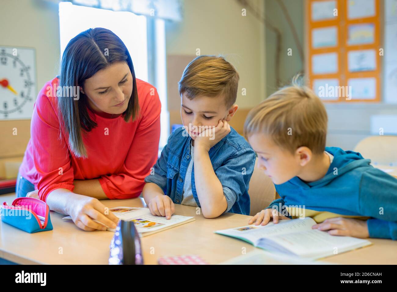 Teacher helping boys in classroom Stock Photo - Alamy