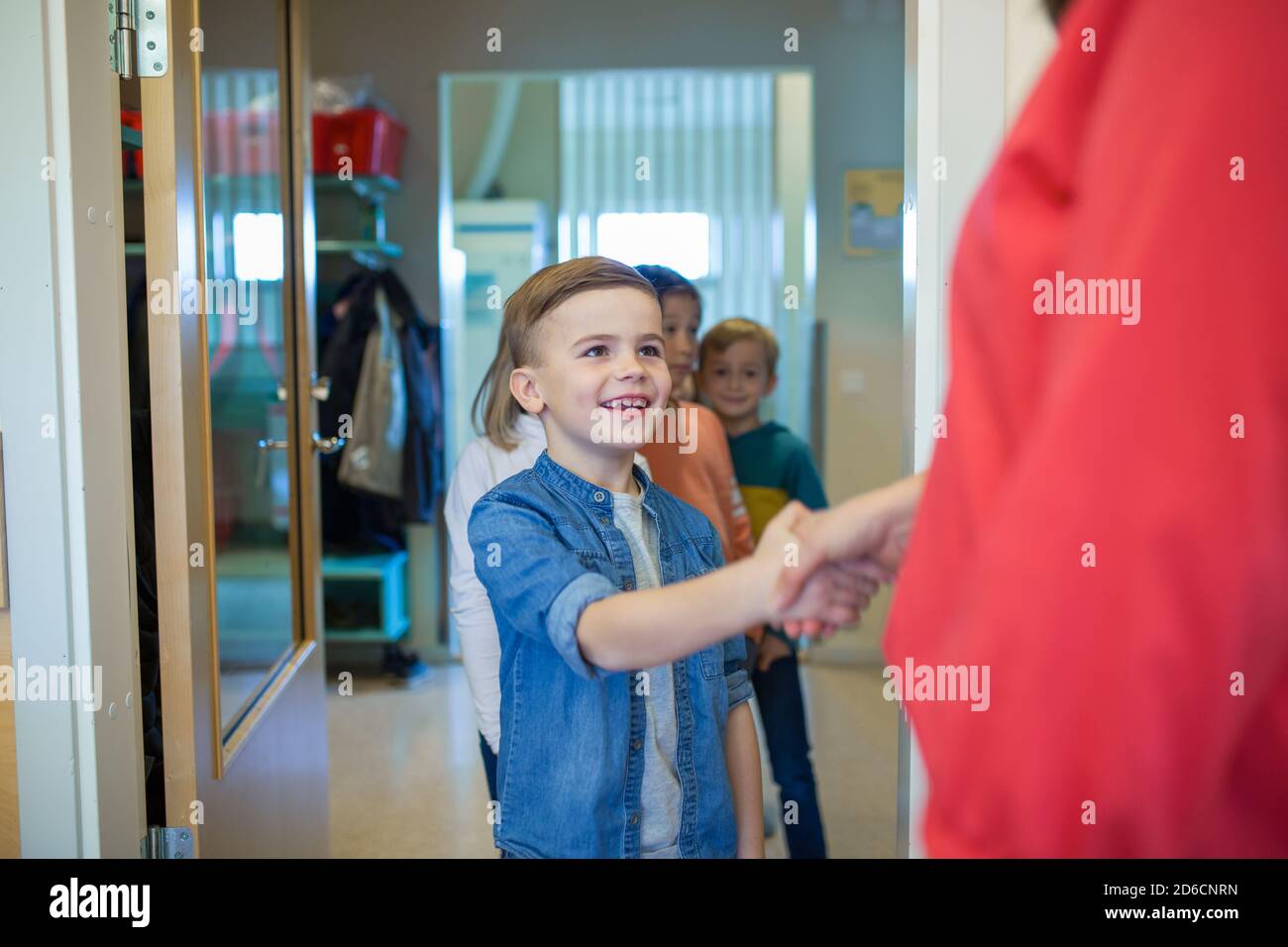 Boy shaking teachers hand Stock Photo - Alamy