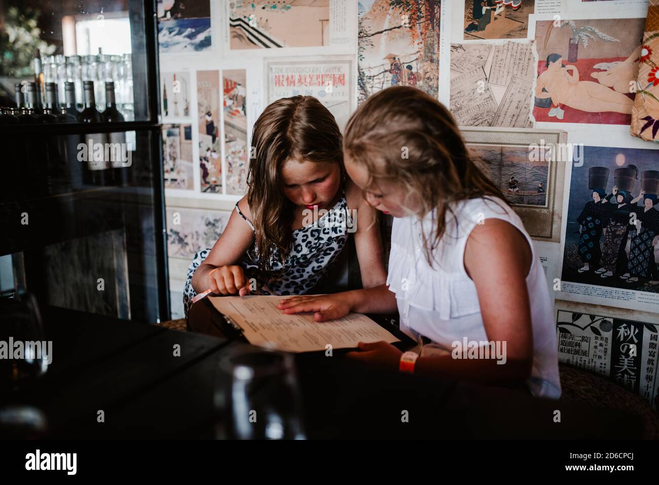 Girls reading menu in cafe Stock Photo - Alamy