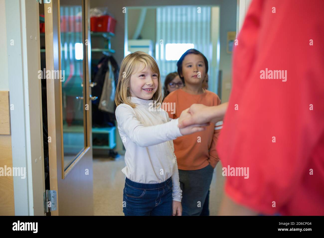 Girl shaking teachers hand Stock Photo - Alamy