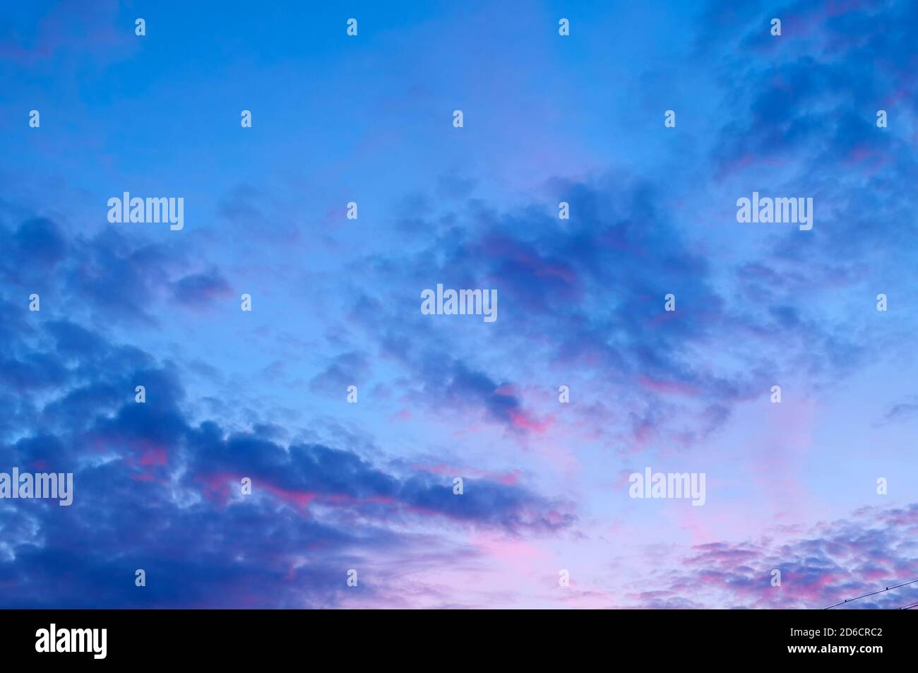 Blue dramatic sky background, sunset clouds lit by evening sunlight ...