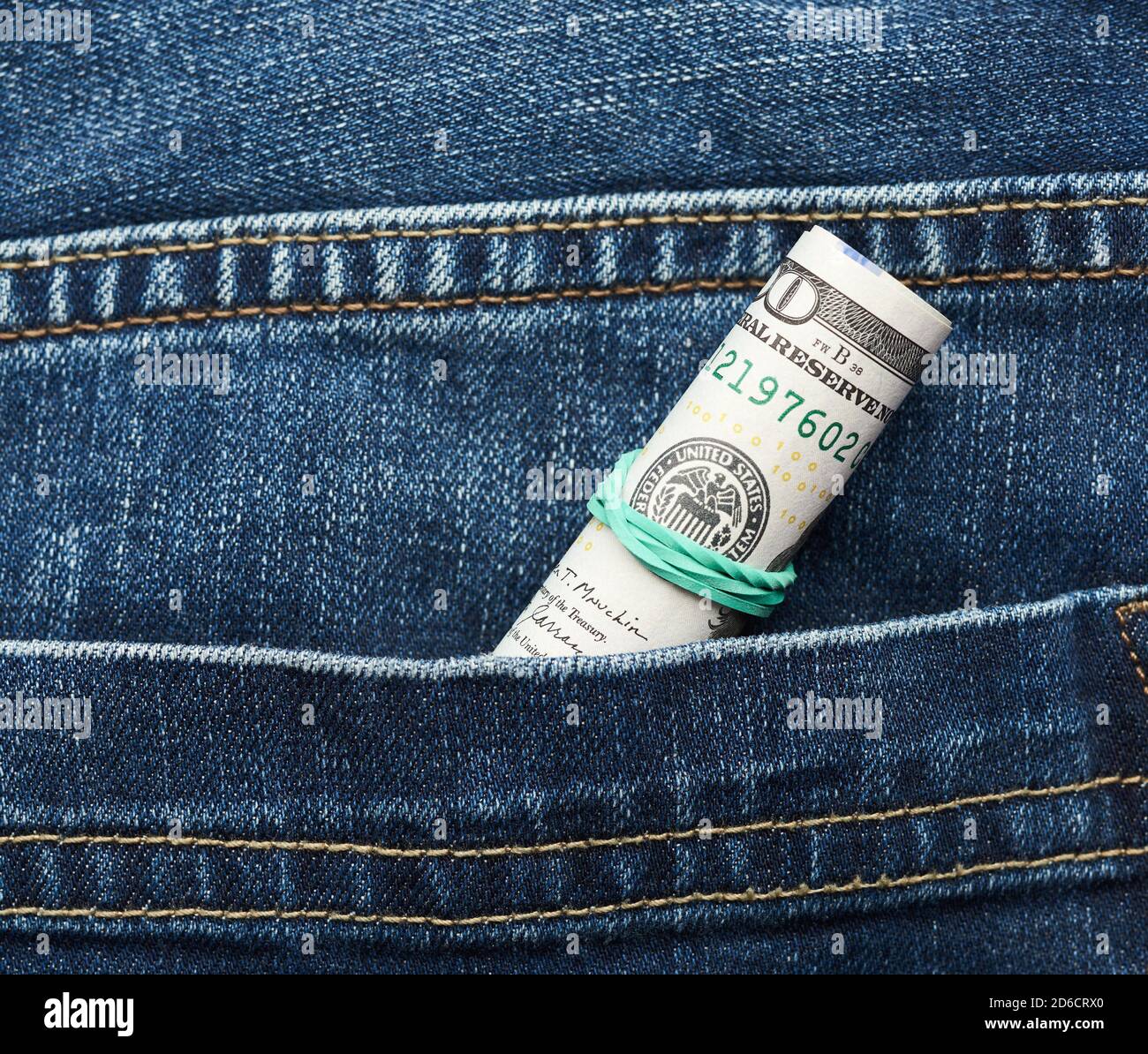 rolled up paper hundred dollar bills and tightened with green rubber ...