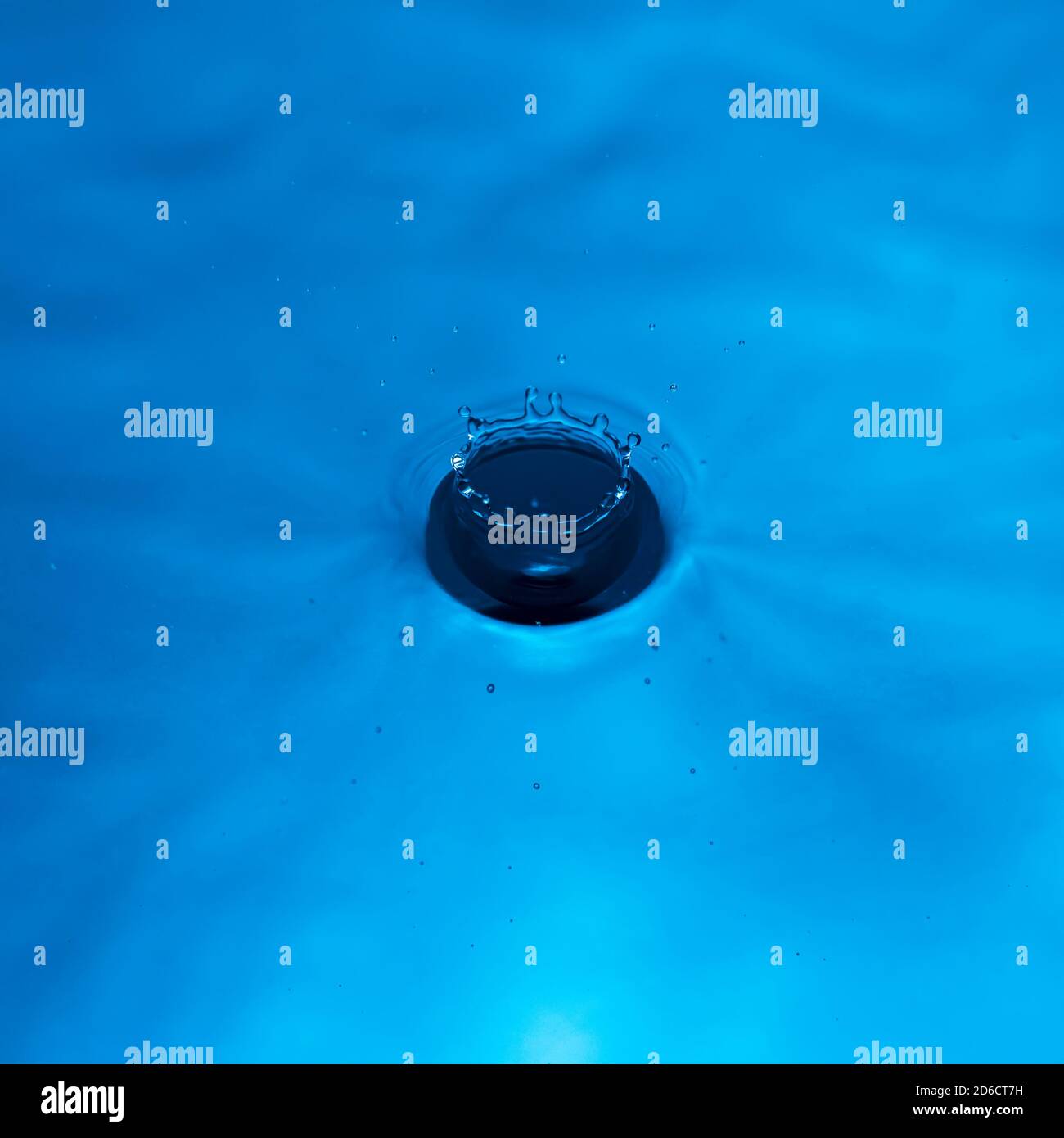 Water drop falling into water making a perfect droplet splash in blue Stock Photo - Alamy