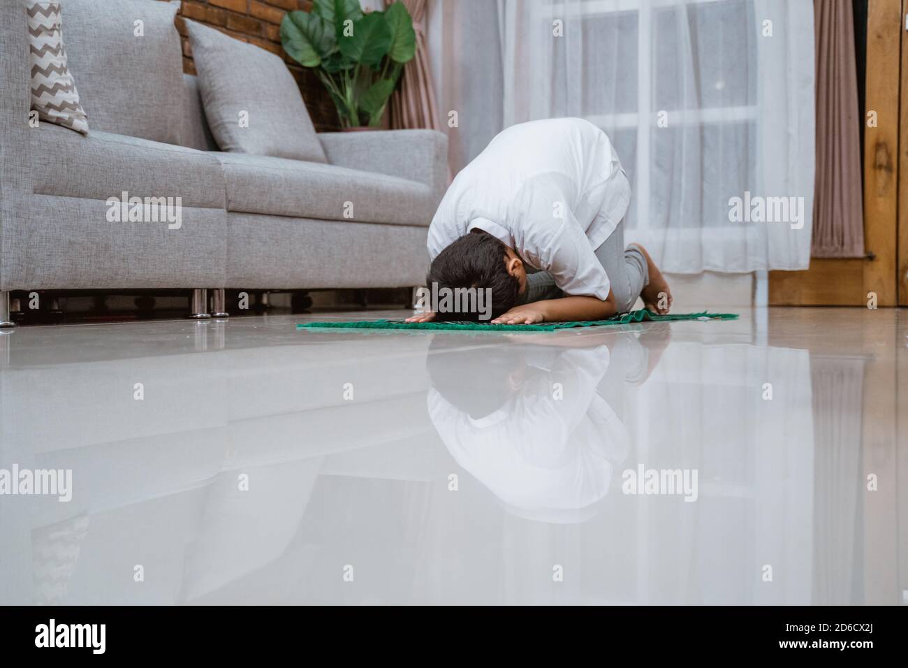 Asian little boy wearing Koko shirt dress prostrate pray on the prayer ...