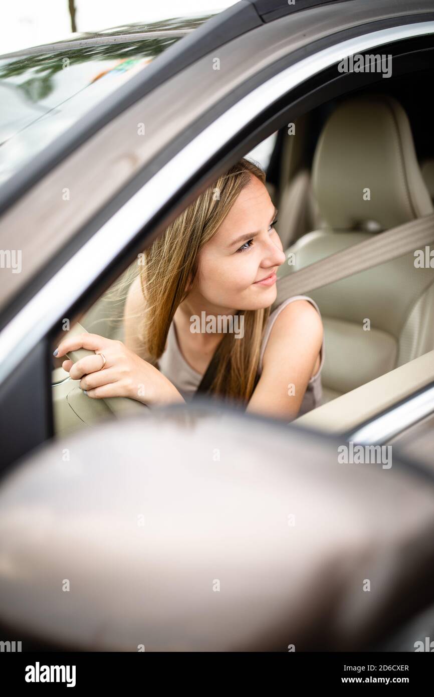 Cute female teen driver enjoying her freshly acquired driving license ...