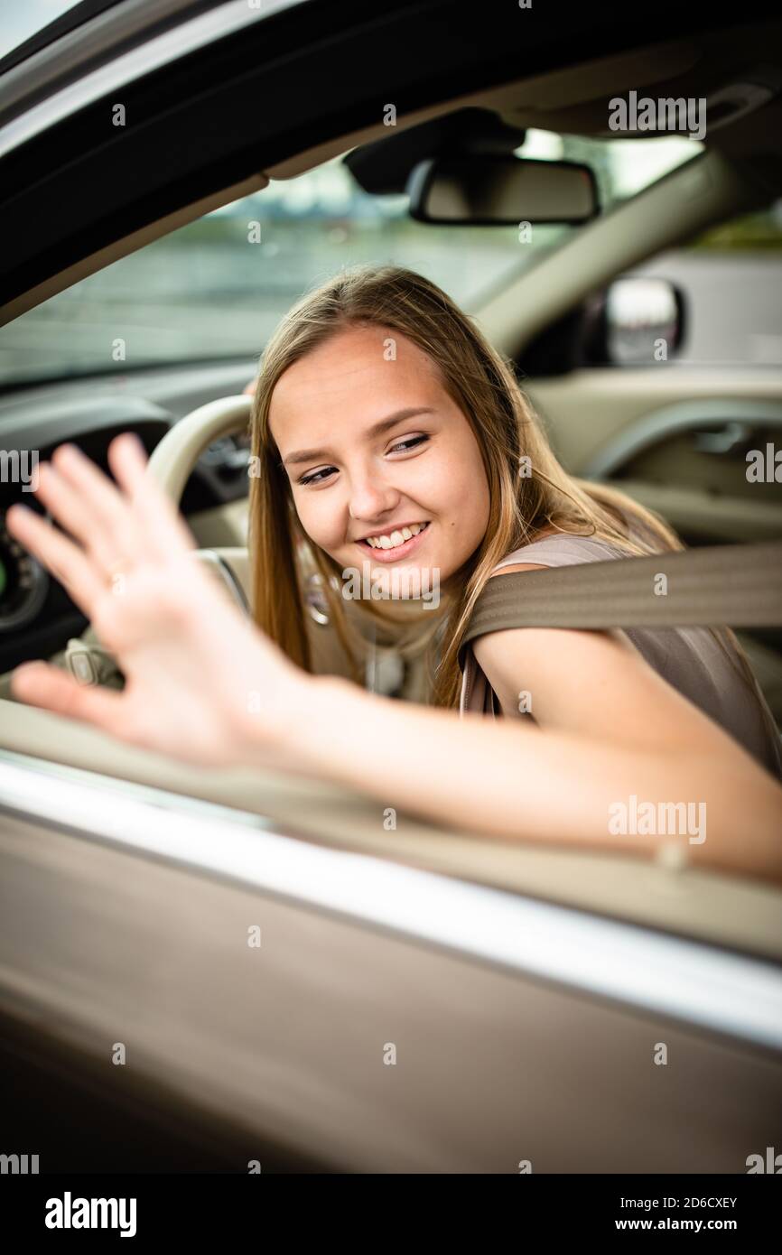Cute female teen driver enjoying her freshly acquired driving license ...