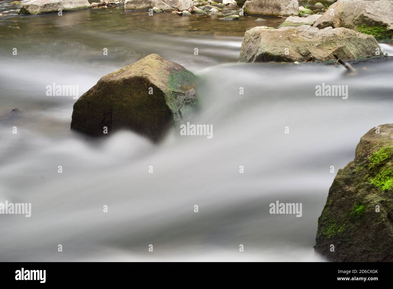 River flowing around stones Stock Photo - Alamy