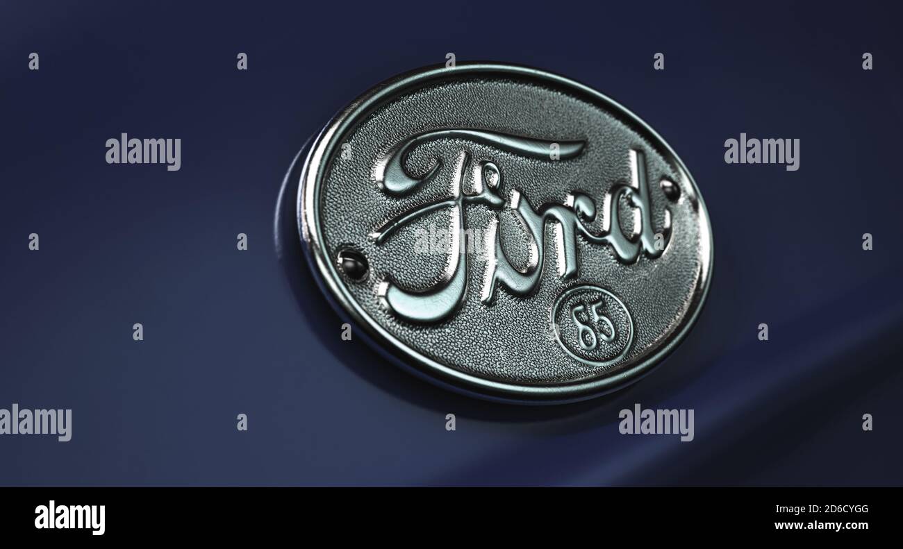 A closeup of a classic vintage chrome ford decal emblem on a car with a ...