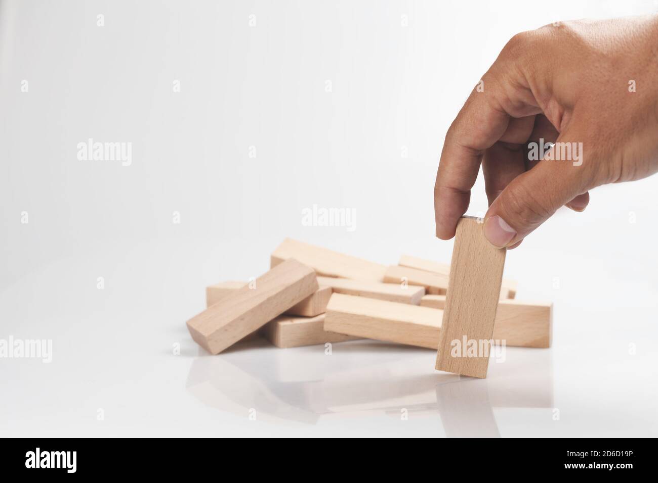 Human hand trying to build a tower with small wooden blocks on the ...