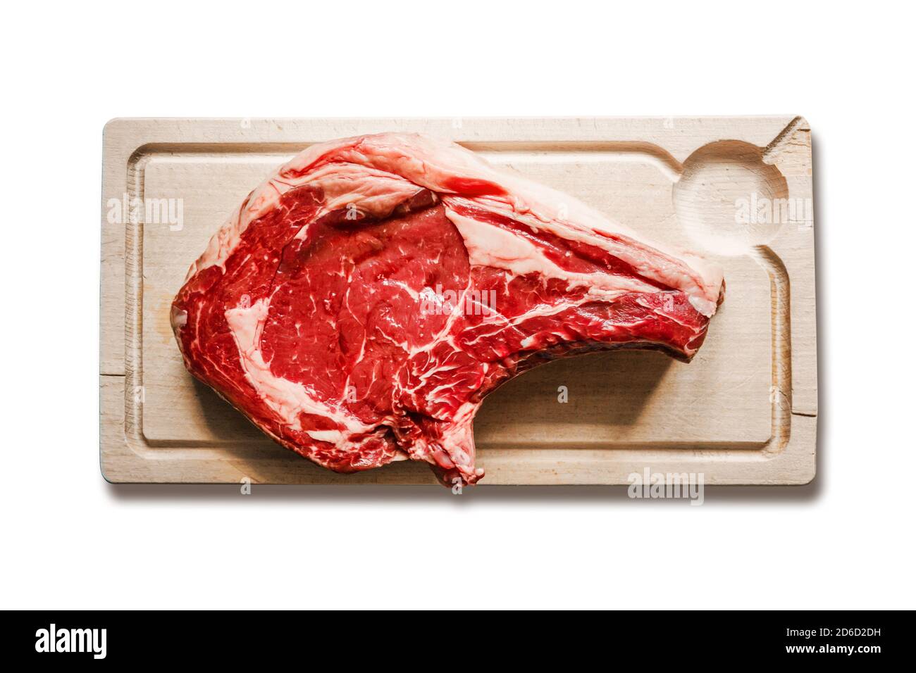 Raw beef prime rib on a cutting board isolated on white background. Top ...