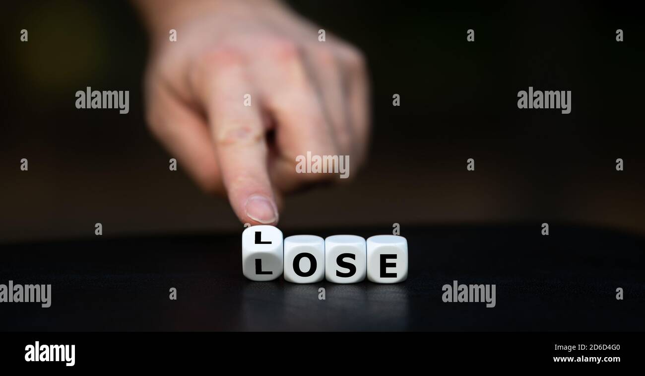 Hand turns dice and changes the word "lose" to "lose Stock Photo - Alamy