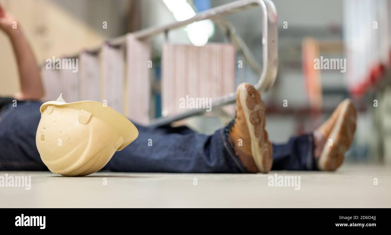 Male body lying on the floor after a work accident. Fallen ladder and ...