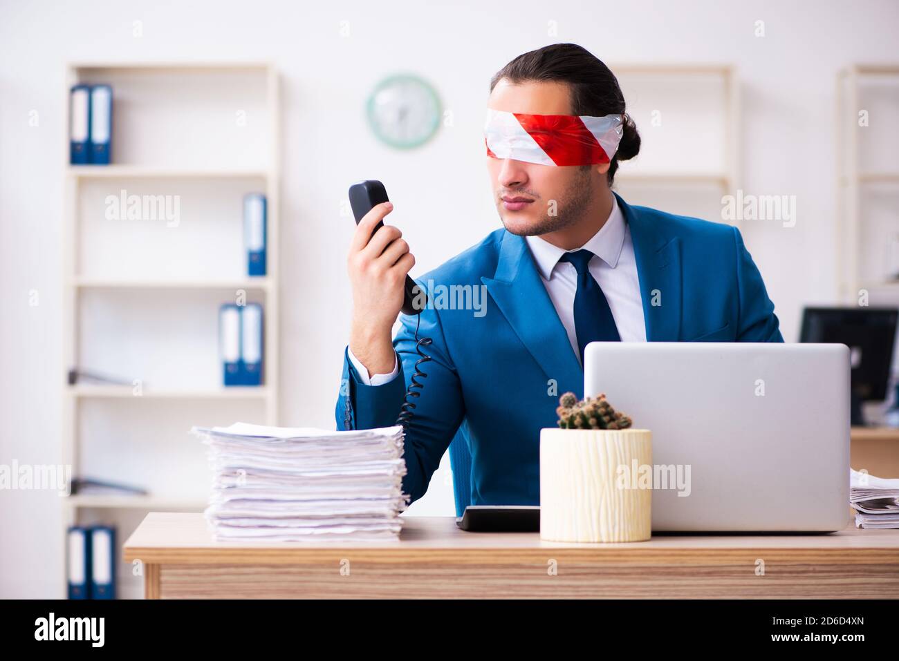 Blindfolded employee working in the office Stock Photo - Alamy