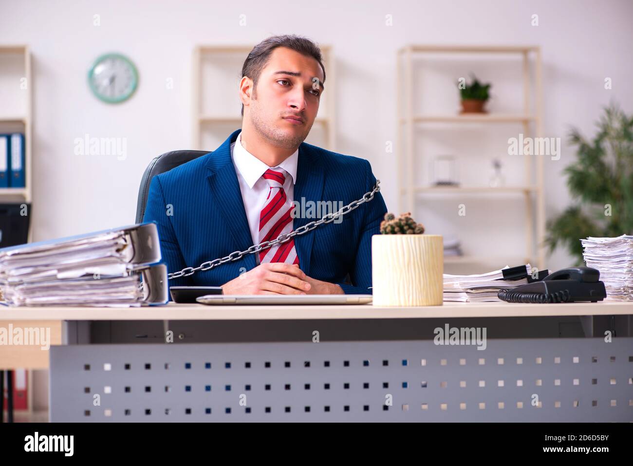 Chained employee working in the office Stock Photo - Alamy