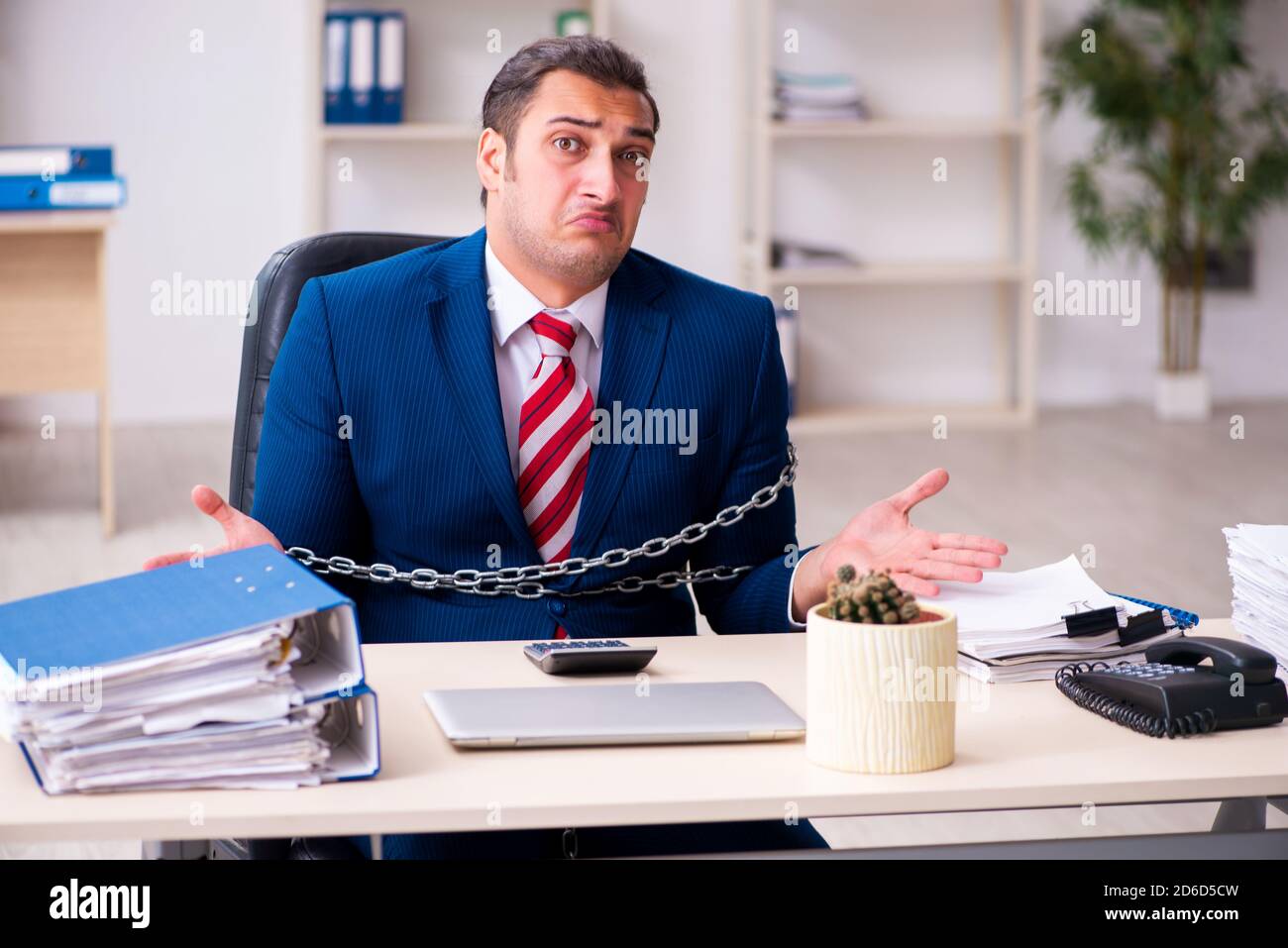 Chained employee working in the office Stock Photo - Alamy