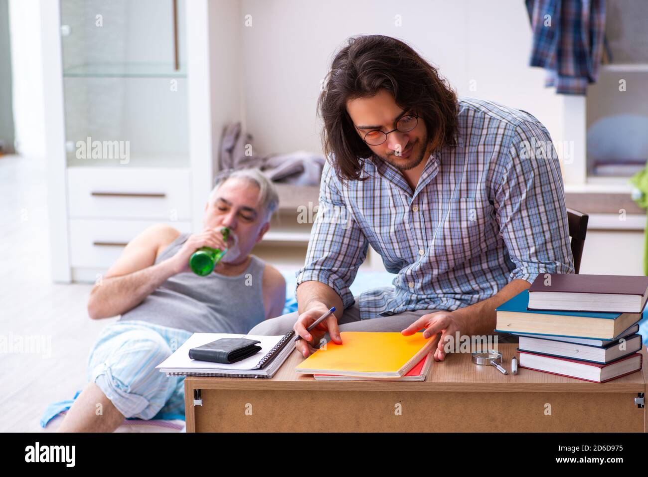 Young son student and dad alcoholic at home Stock Photo - Alamy