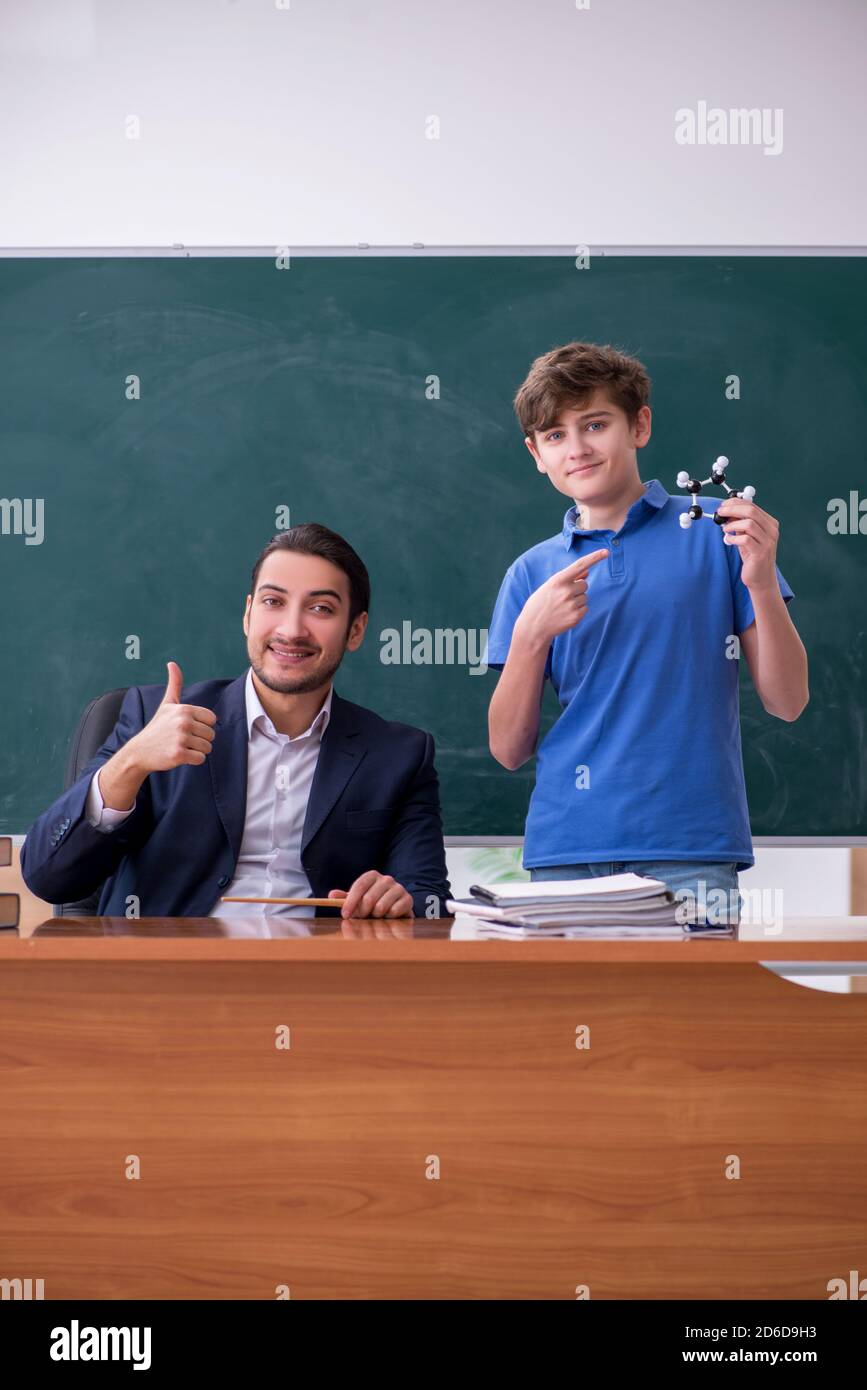 Male teacher and schoolboy in the classroom Stock Photo - Alamy