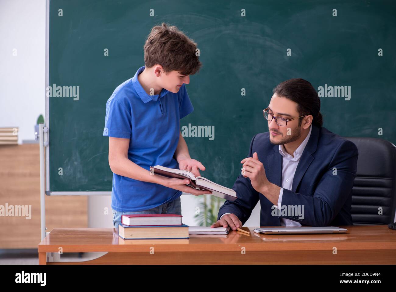 Male teacher and schoolboy in the classroom Stock Photo - Alamy