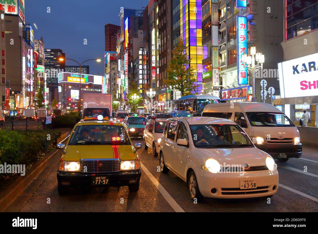 TOKYO, JAPAN - NOVEMBER 30, 2016: Cars drive under the neon lights of ...