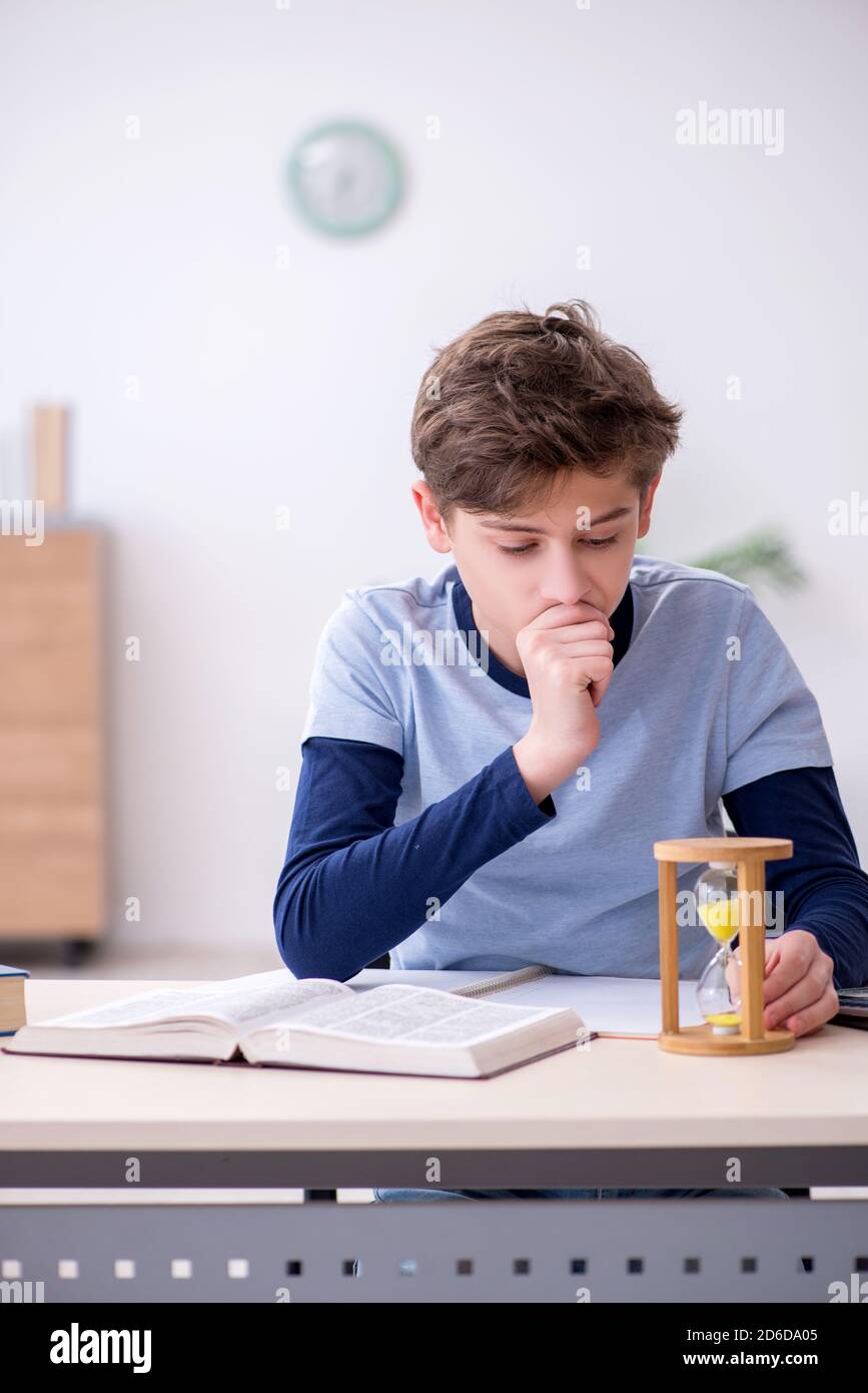 Boy preparing for exams in time management concept Stock Photo - Alamy