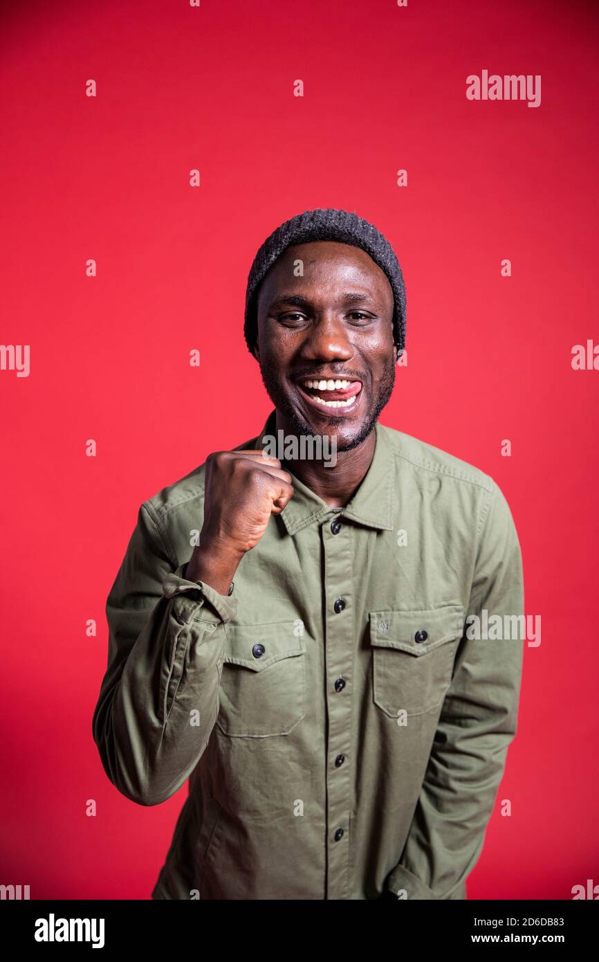 Young black man with happy winning facial expression and clenched fist ...