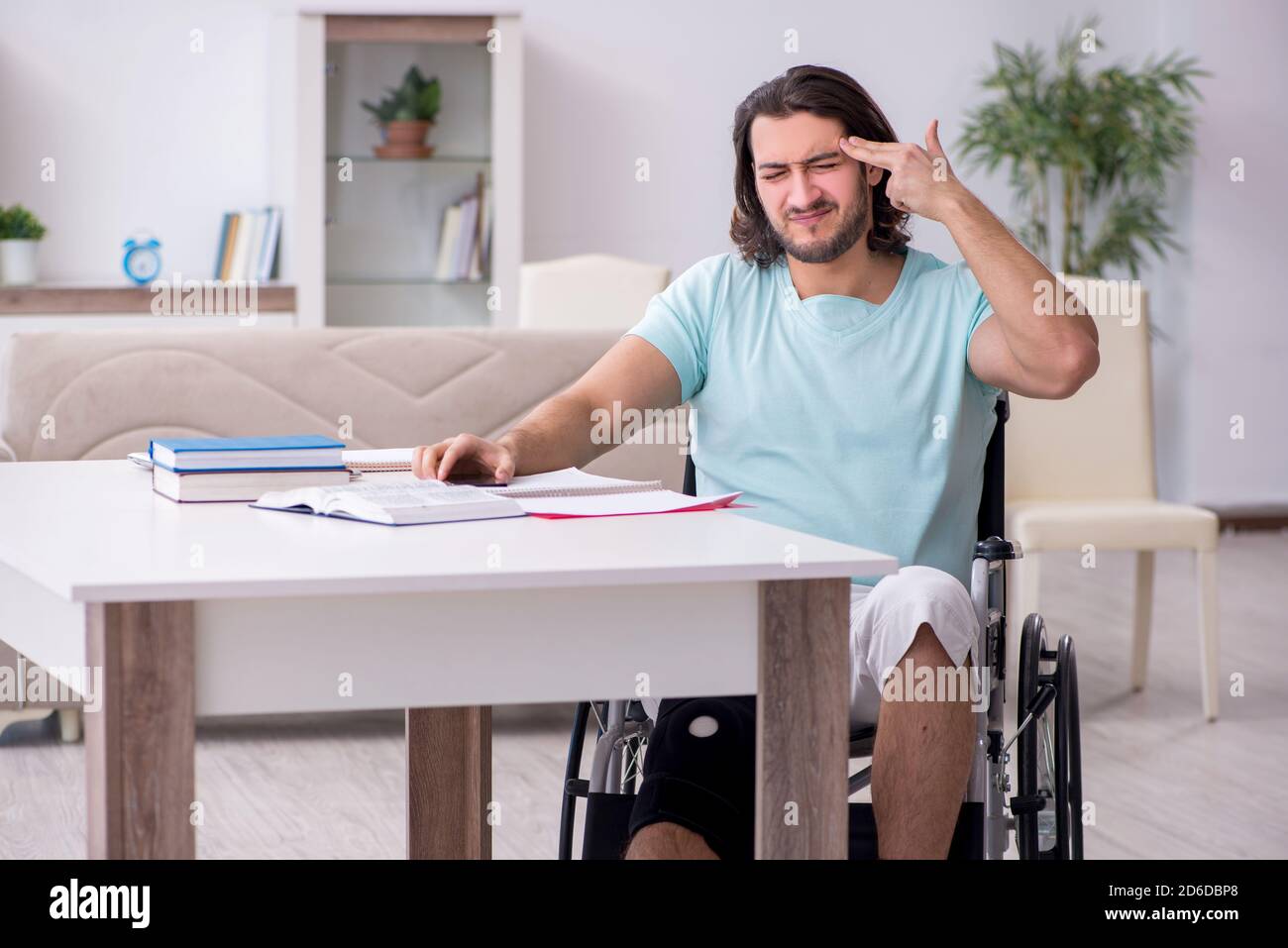 Young student in wheelchair studying at home Stock Photo - Alamy