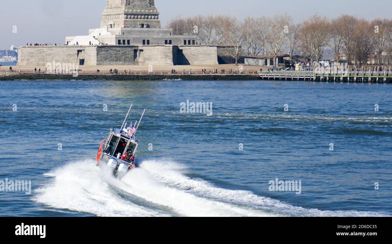 Statue of Liberty in NY Harbor with racing US Coast Guard Patrol Boat ...