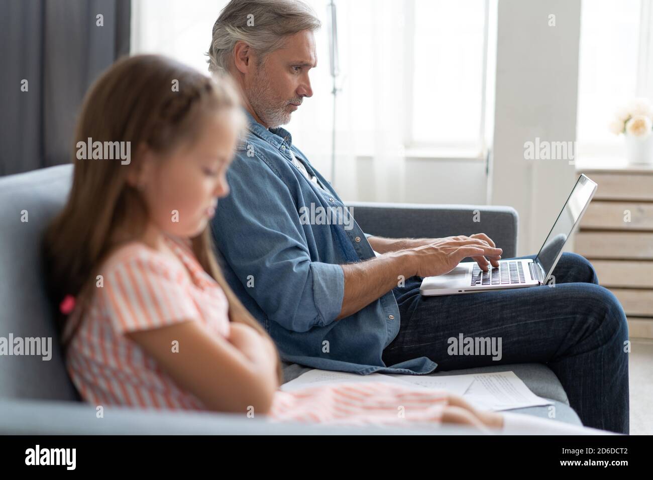 No Time For Child. Grey-haired dad busy with laptop, working online at ...
