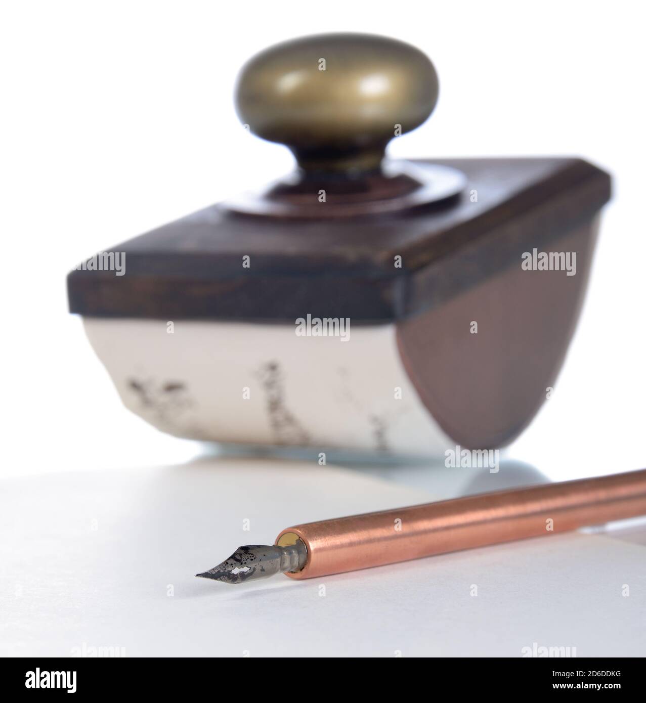 Close-up of copper ink pen and paperweight a on a white background. Low ...