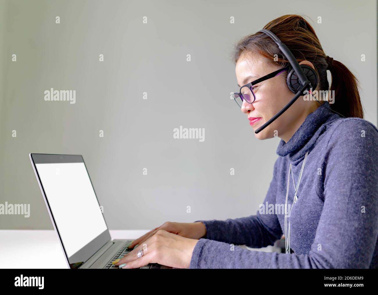 Happy smiling young asian support phone operator in headset with laptop ...