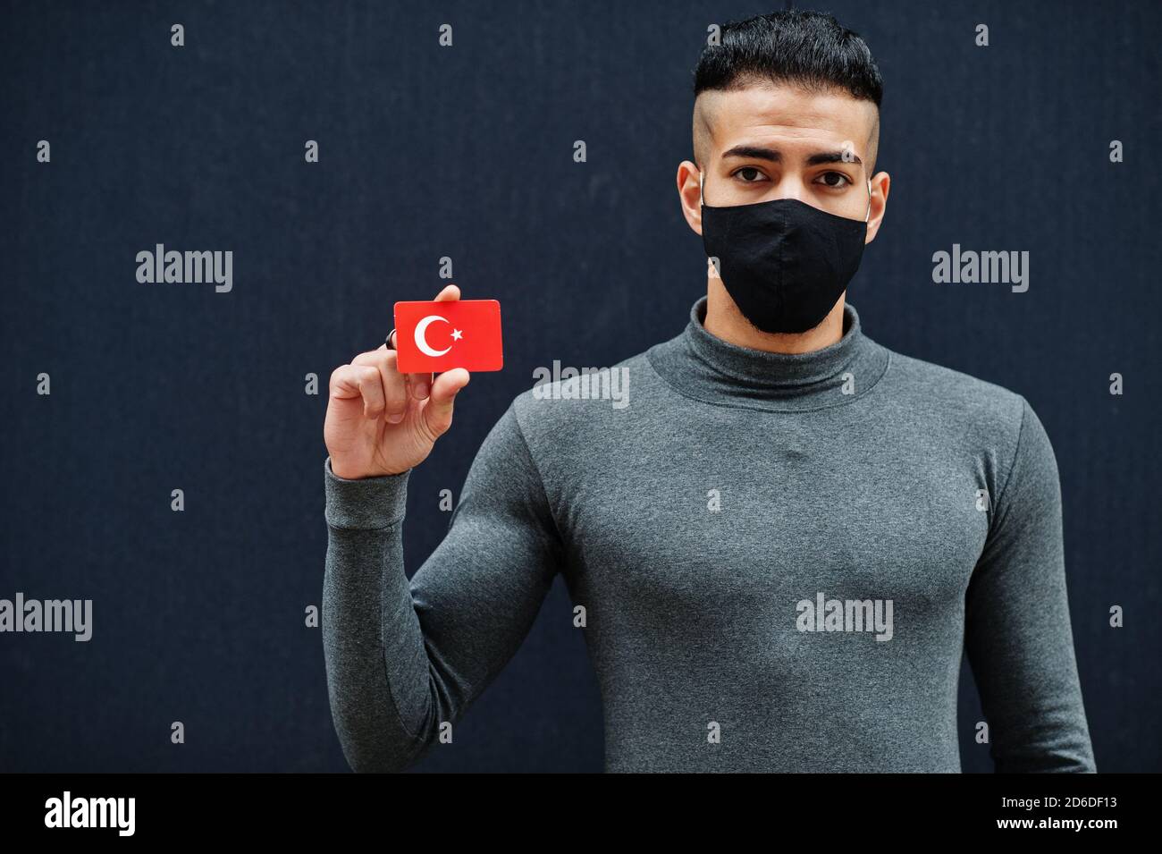 Middle eastern man in gray turtleneck and black face protect mask show ...