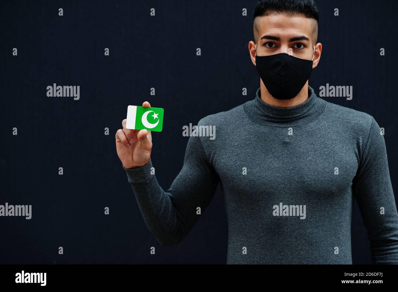 Middle eastern man in gray turtleneck and black face protect mask show ...