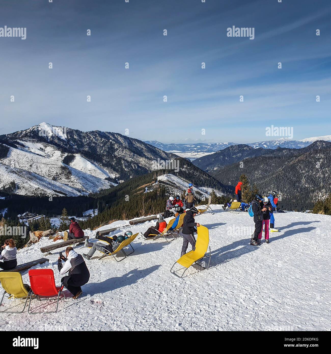 Group of skiers taking a break and sunbathing on the slope of Chopok ...