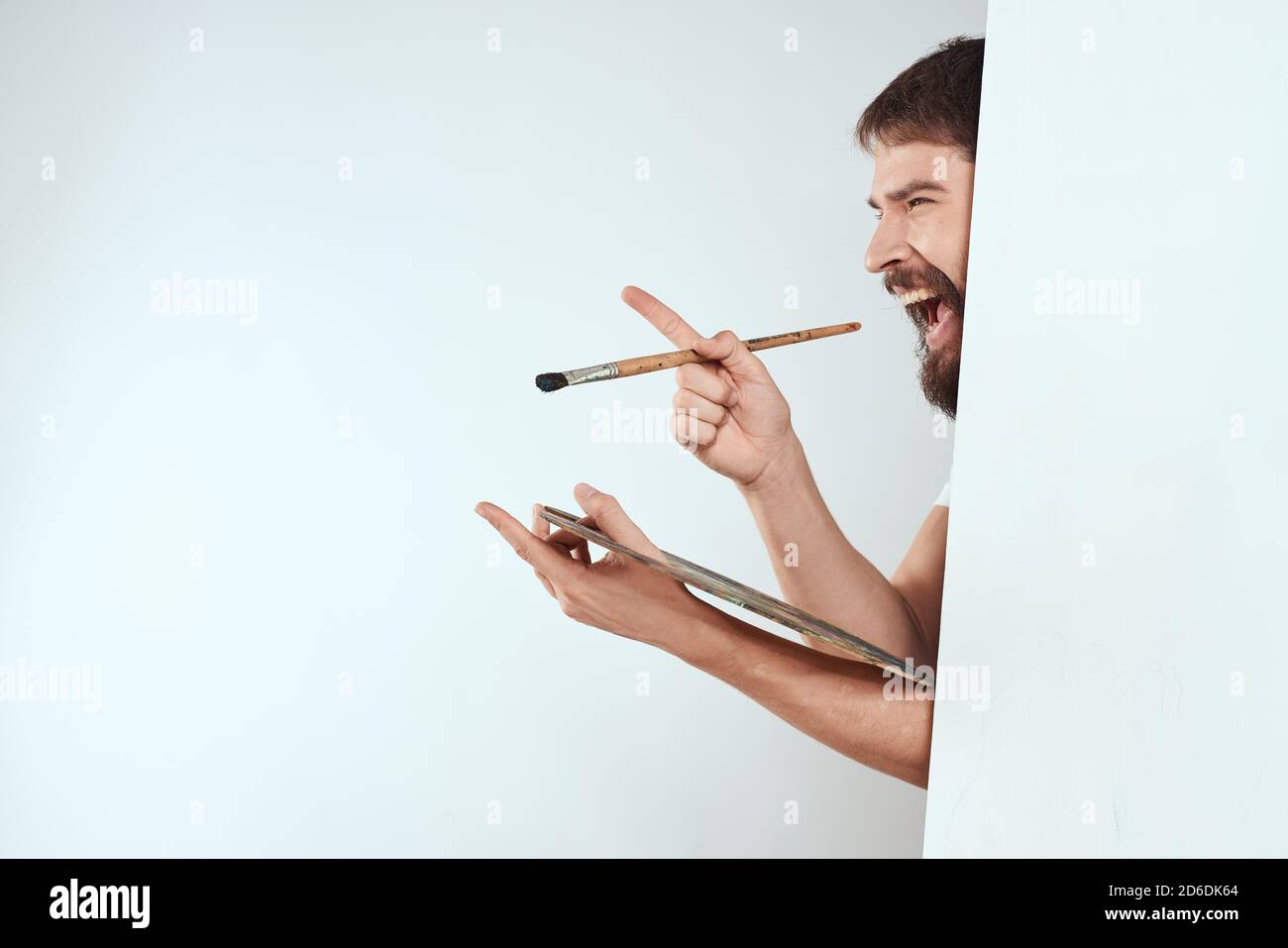 Male artist hiding behind an easel palette drawing art Stock Photo - Alamy