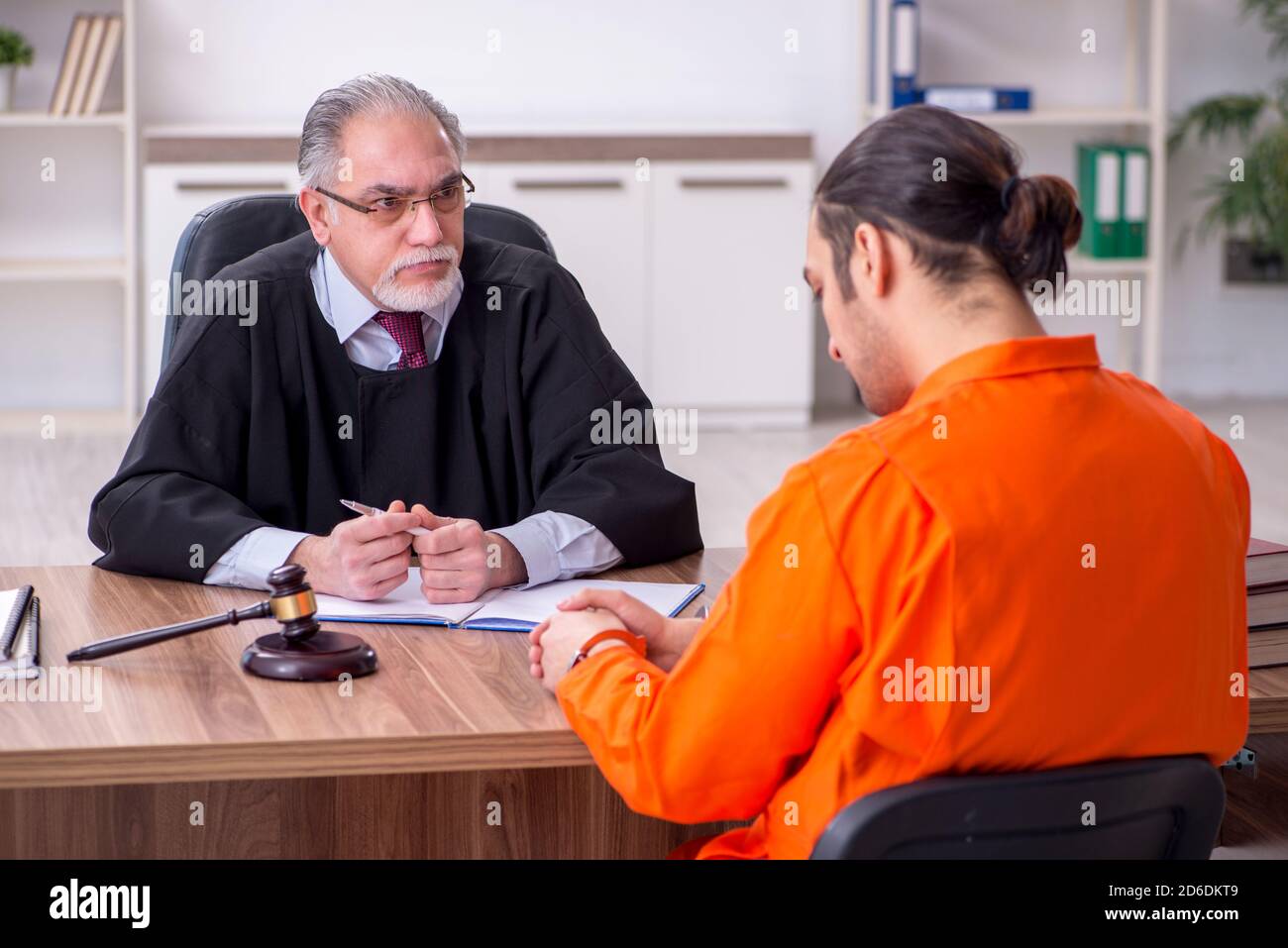 Old judge meeting with young captive in courthouse Stock Photo - Alamy