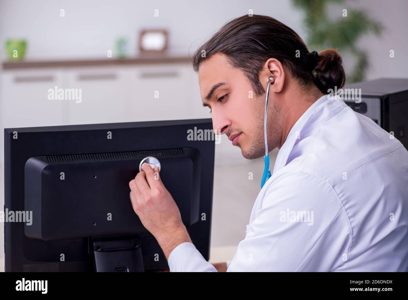 Young doctor with stethoscope repairing computer Stock Photo - Alamy