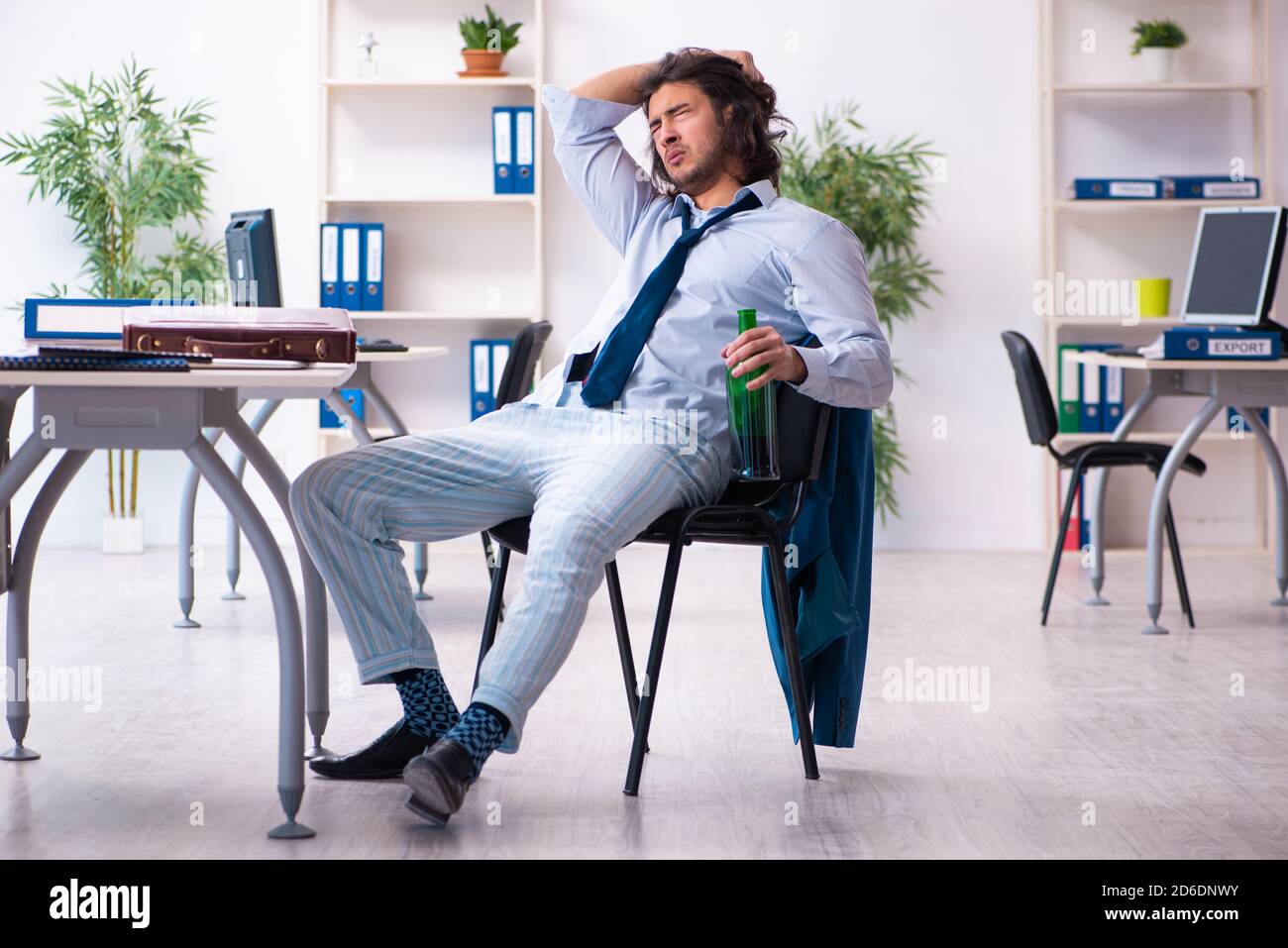Male employee coming to work after the party Stock Photo - Alamy
